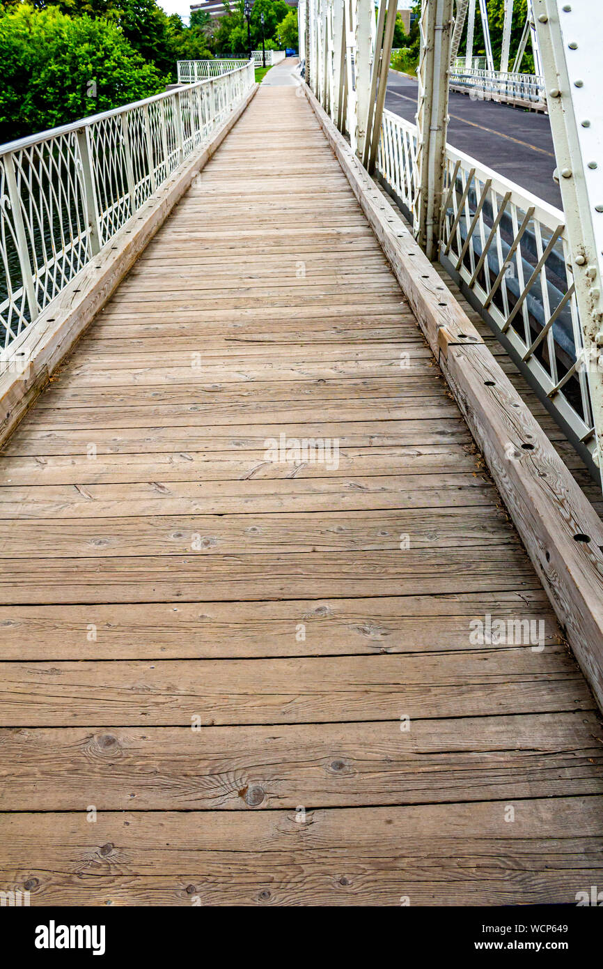 A wooden walkway extends from the sidewalk and guides pedestrians ...