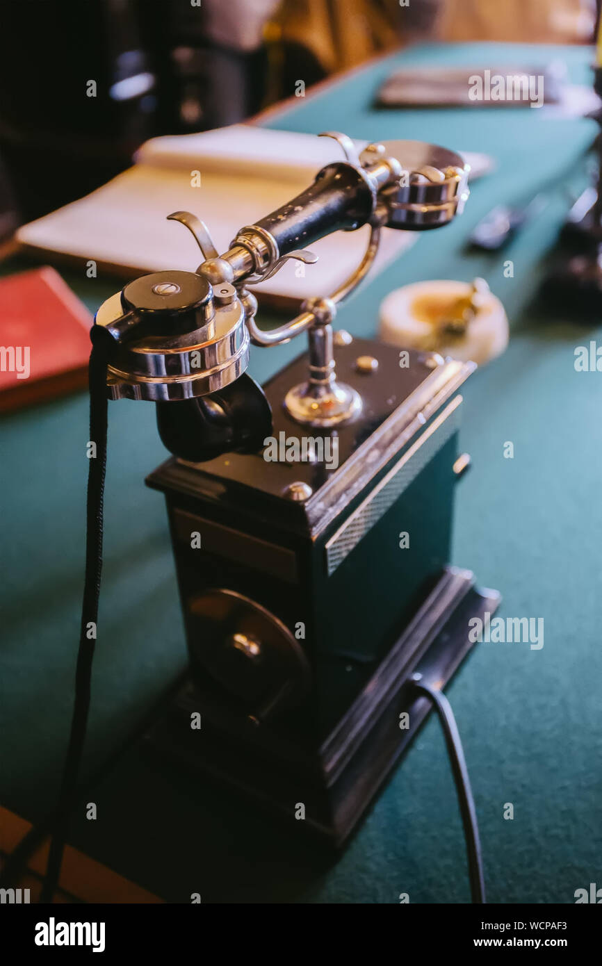 Old antique vintage telephone on green table Stock Photo - Alamy