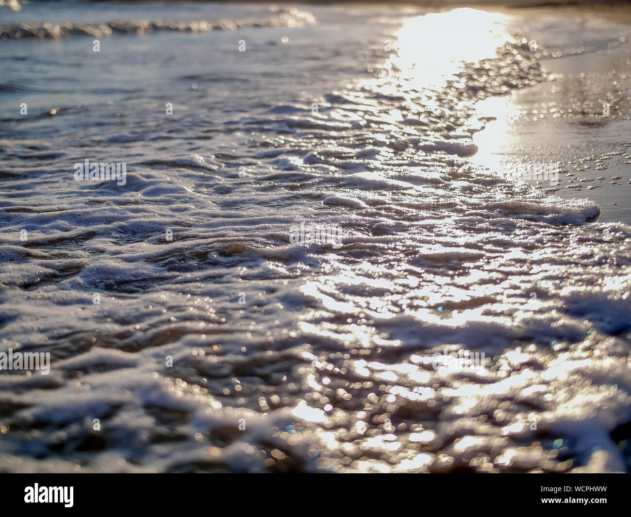 Glare of the sun on the sea waves during sunset Stock Photo - Alamy