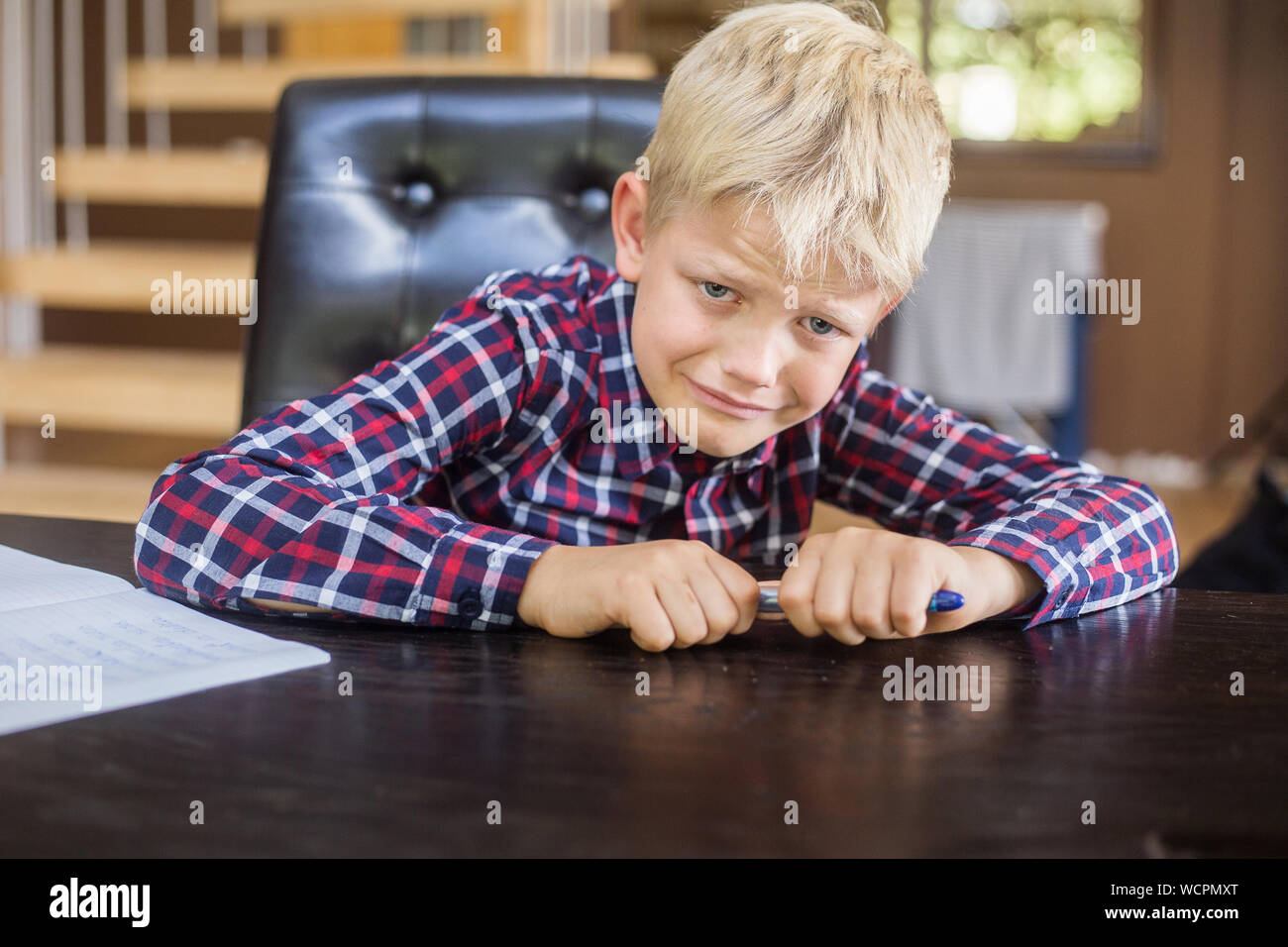 Sad schoolboy writing to notebook at home. Homework. Education ...