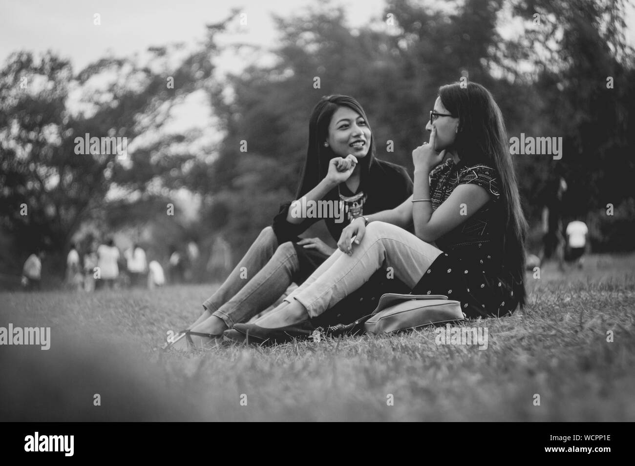 Women sitting on grass hi-res stock photography and images - Alamy