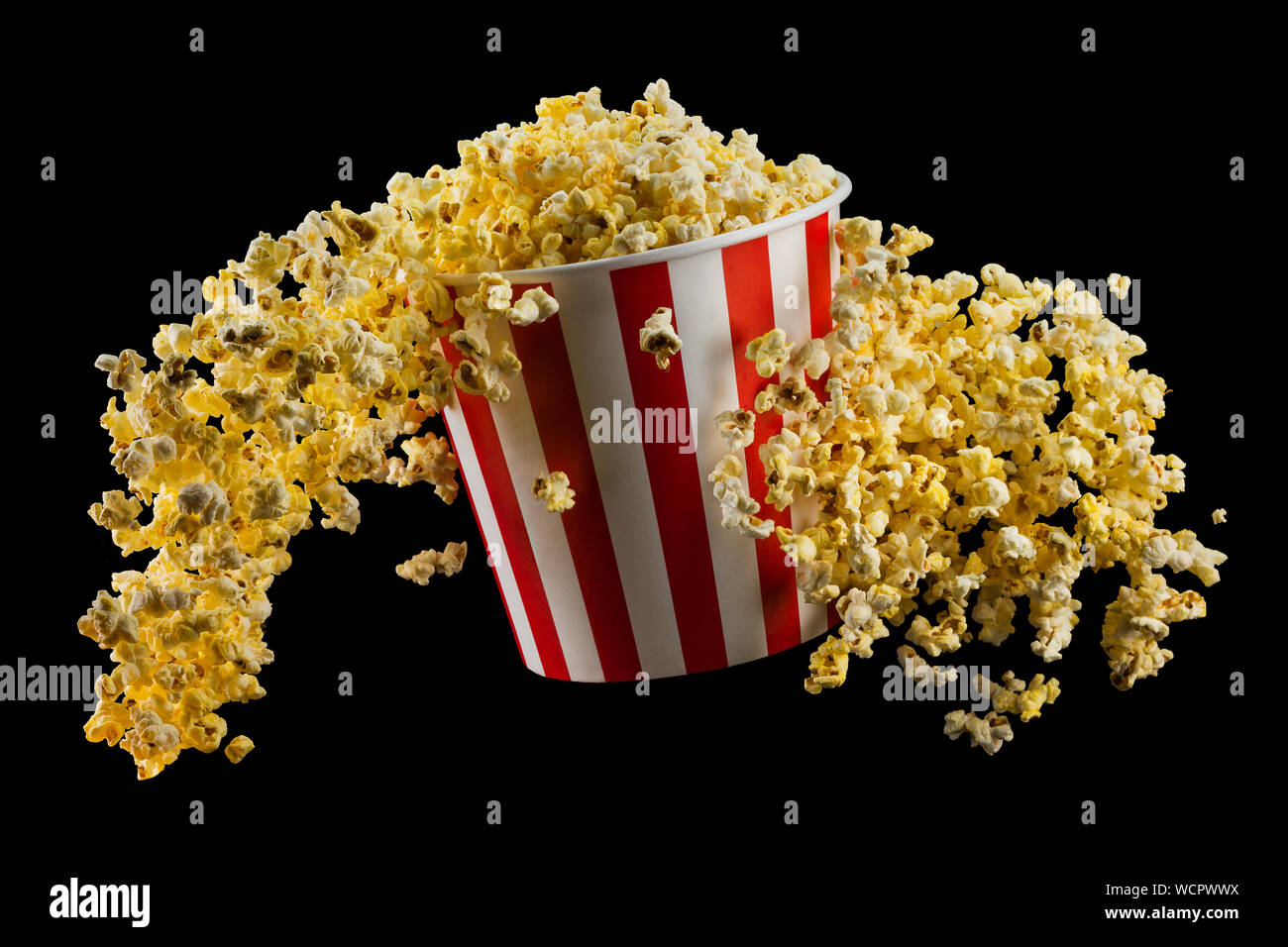 Flying popcorn from striped bucket isolated on black background Stock ...