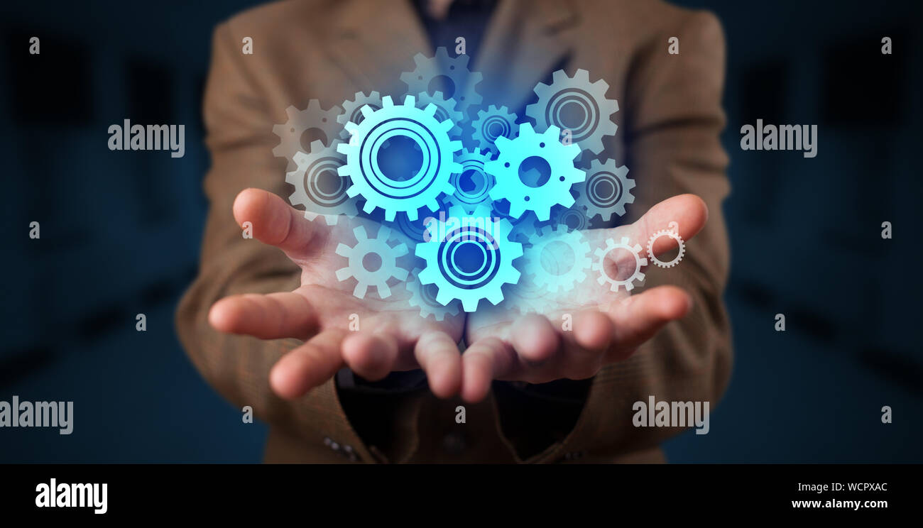 Hand holding gears in his hand Stock Photo - Alamy