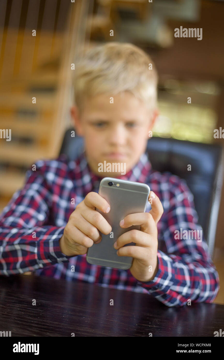 Cute little caucasian boy in a shirt talking on the phone. Modern ...