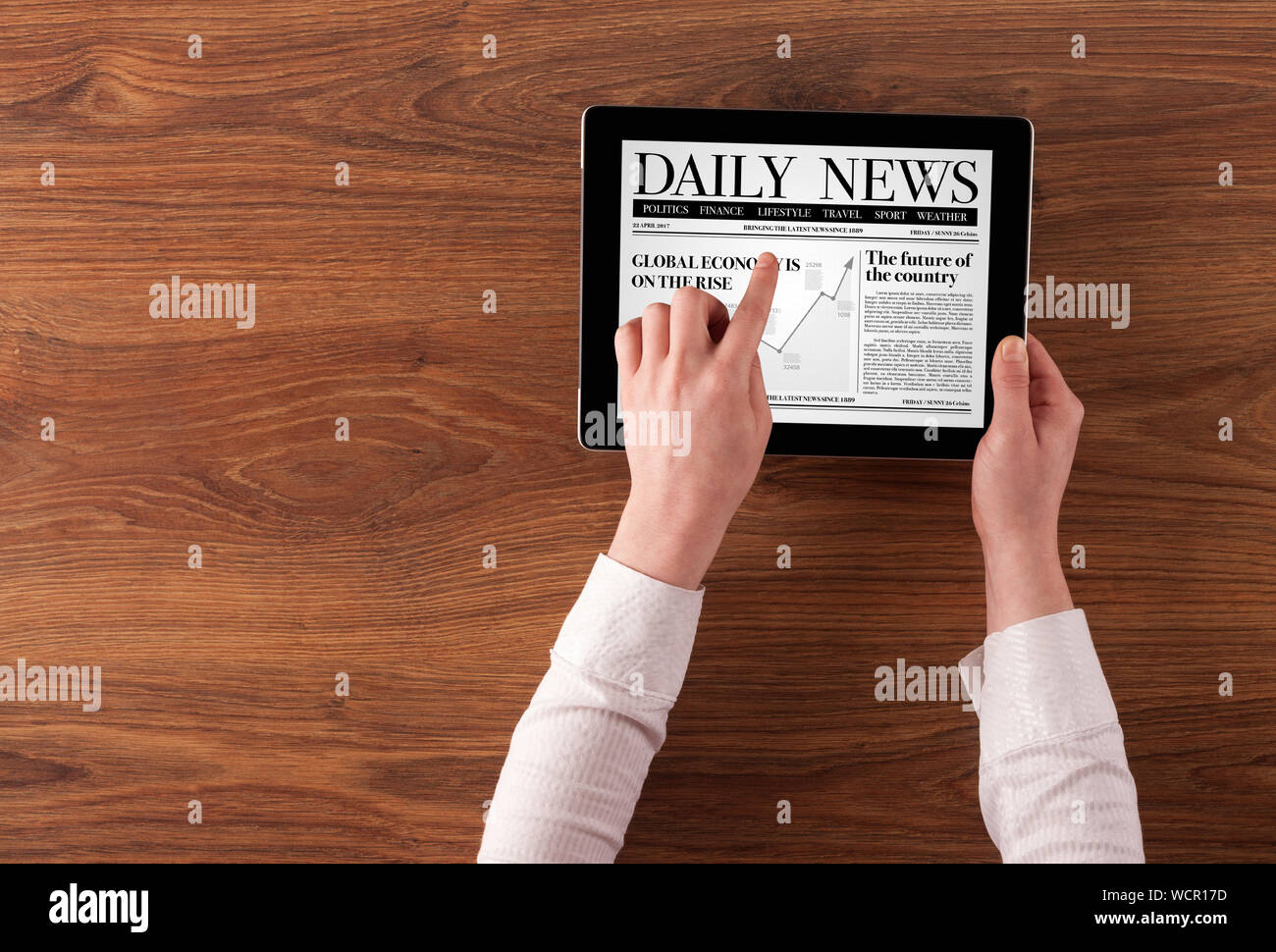 Hand with tablet reading news on tablet Stock Photo - Alamy