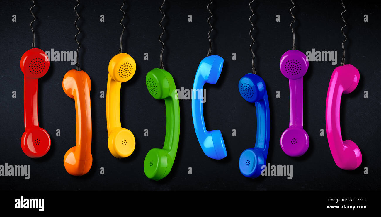 row of colorful rainbow colored old fashioned retro phone reciever with ...