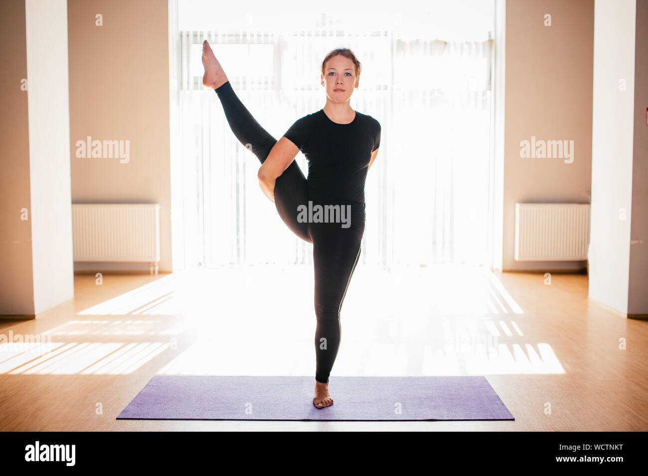 Woman size plus doing physical exercise and stretching on a mat ...