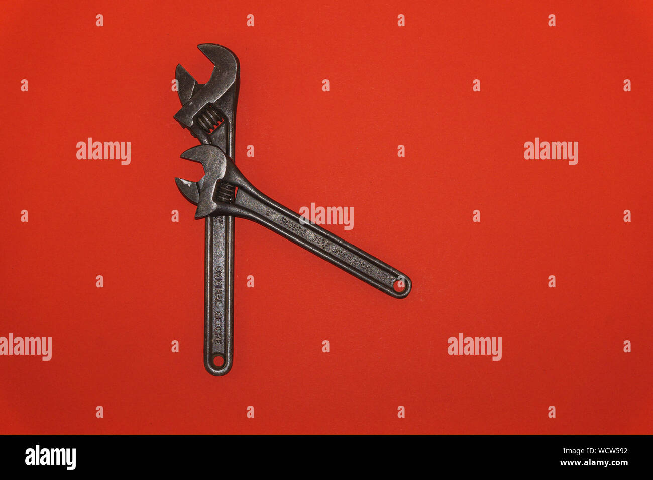 Old metal wrenches on a red background Stock Photo - Alamy