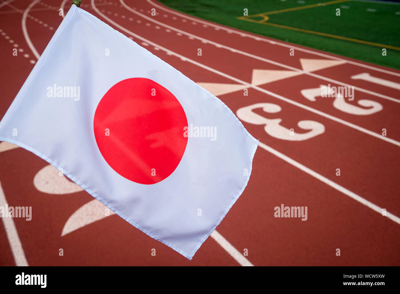 Bright sunny view of a Japanese flag flying in front of the numbered ...