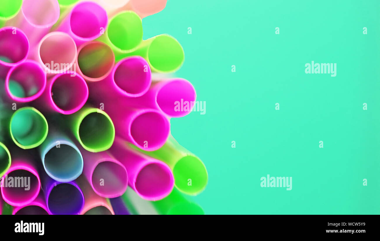 Unusual top view of many multicolored plastic cocktail tubes on blue ...
