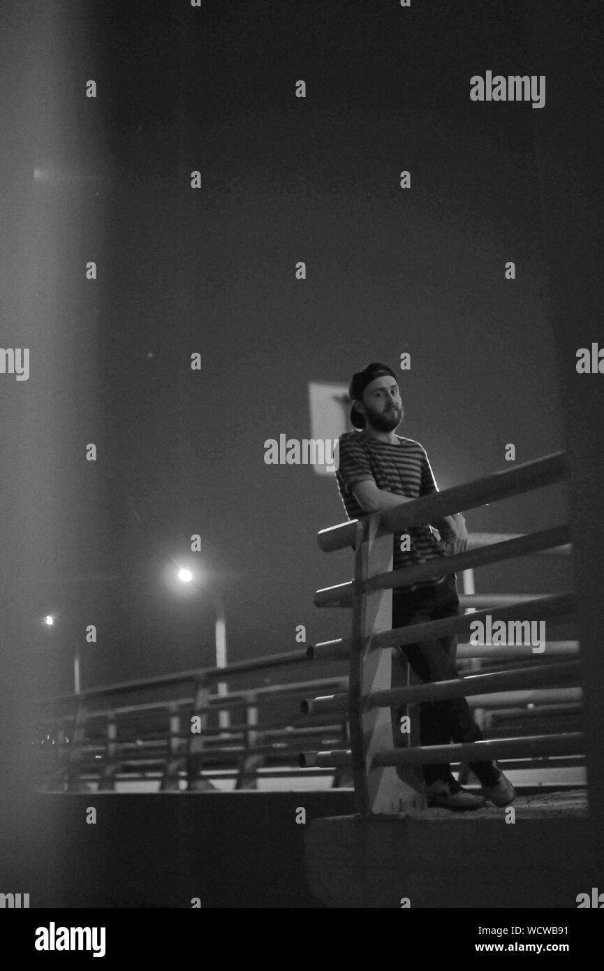 Young Man Standing On Bridge At Night Stock Photo - Alamy