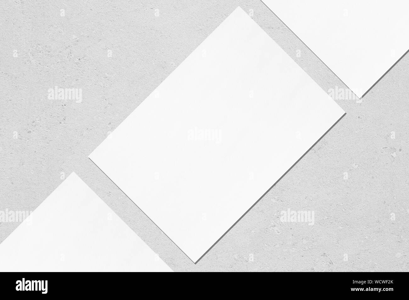 Close up of three empty white rectangle poster mockups lying diagonally ...