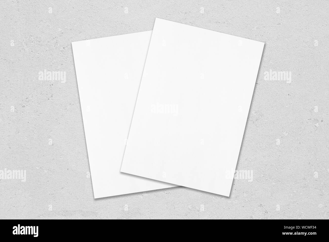 Two empty white rectangle poster mockups lying diagonally on top of ...