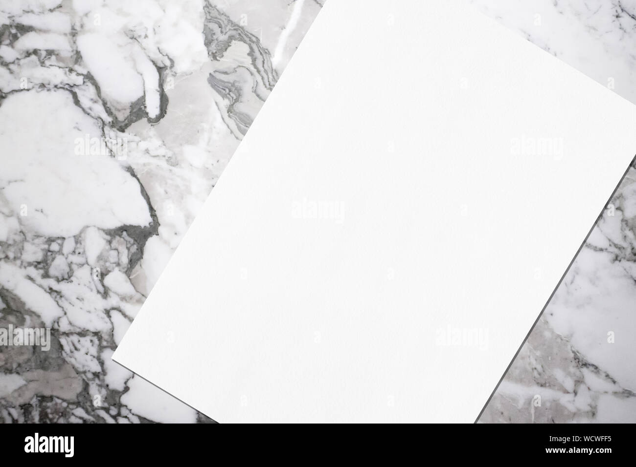 Close up of empty white rectangle poster mockup lying diagonally with ...