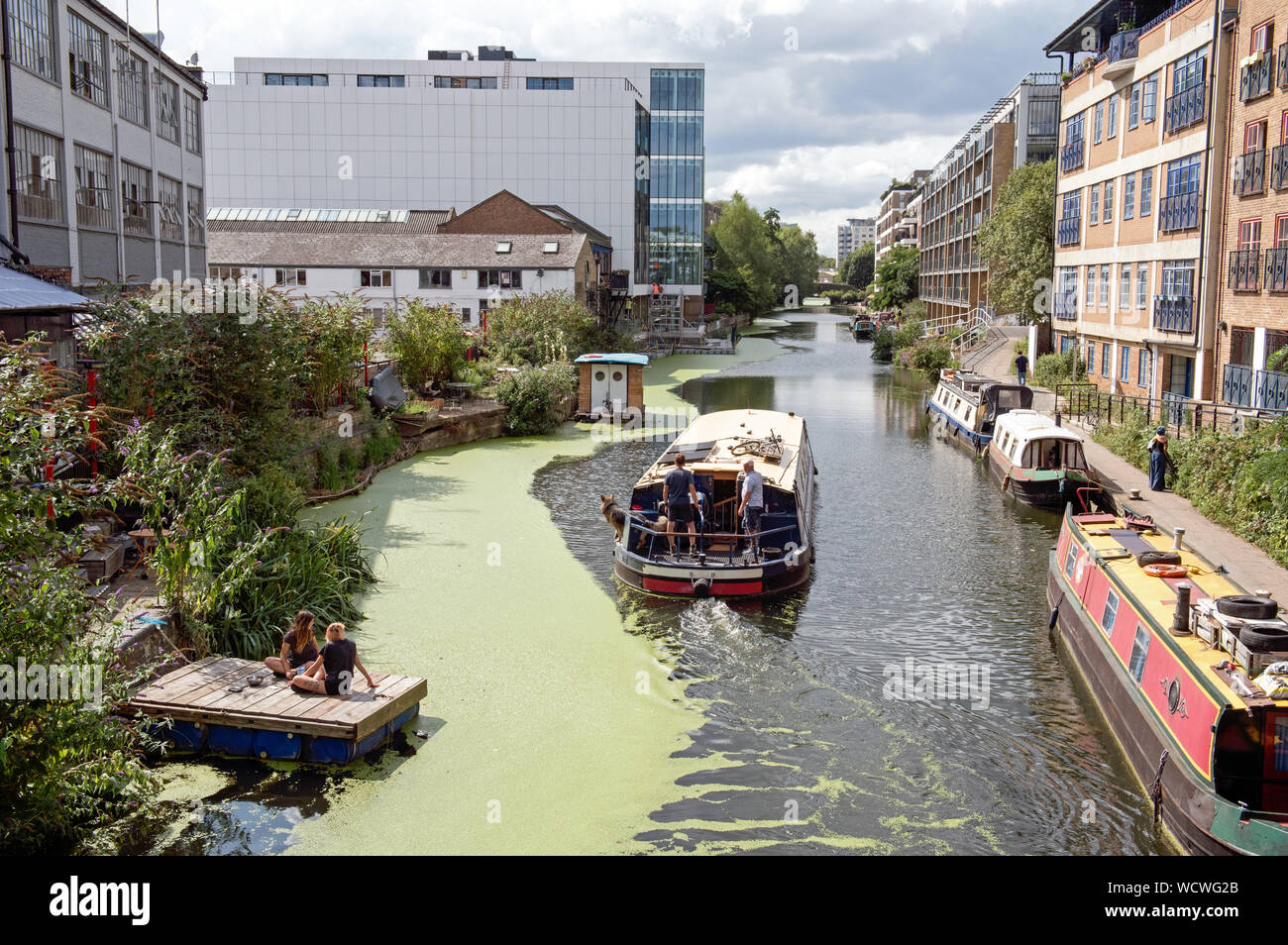 Houseboat travelling along the Regent's Canal with girls on raft in ...
