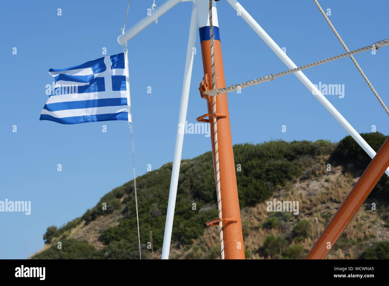 Greek flag on the mast of a sailing boat. Travelling in the blue sea ...