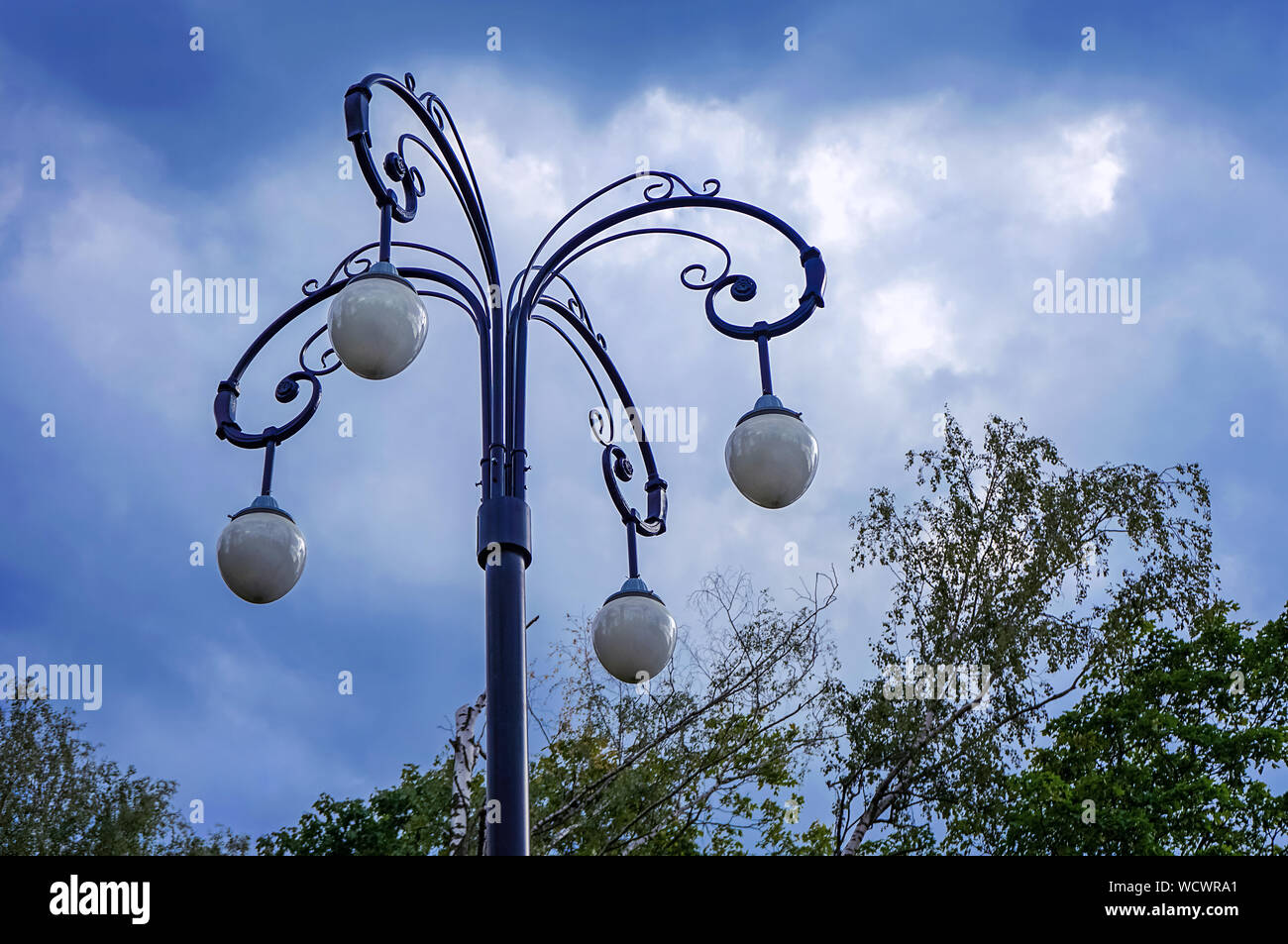Street lamp with four white teardrop-shaped plafonds Stock Photo - Alamy