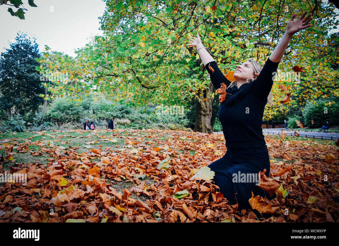 Woman throwing leaves in the air hi-res stock photography and images ...