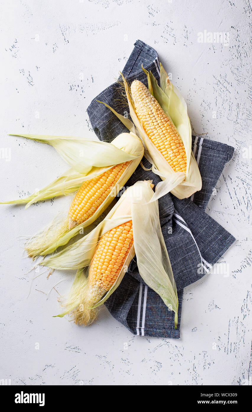 Raw corn on concrete table Stock Photo - Alamy
