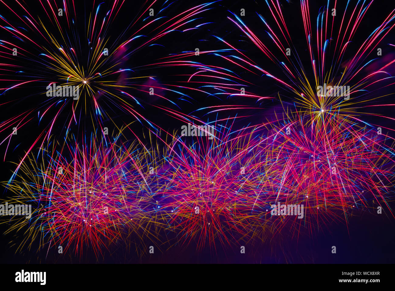Colorful fireworks in night sky background Stock Photo - Alamy