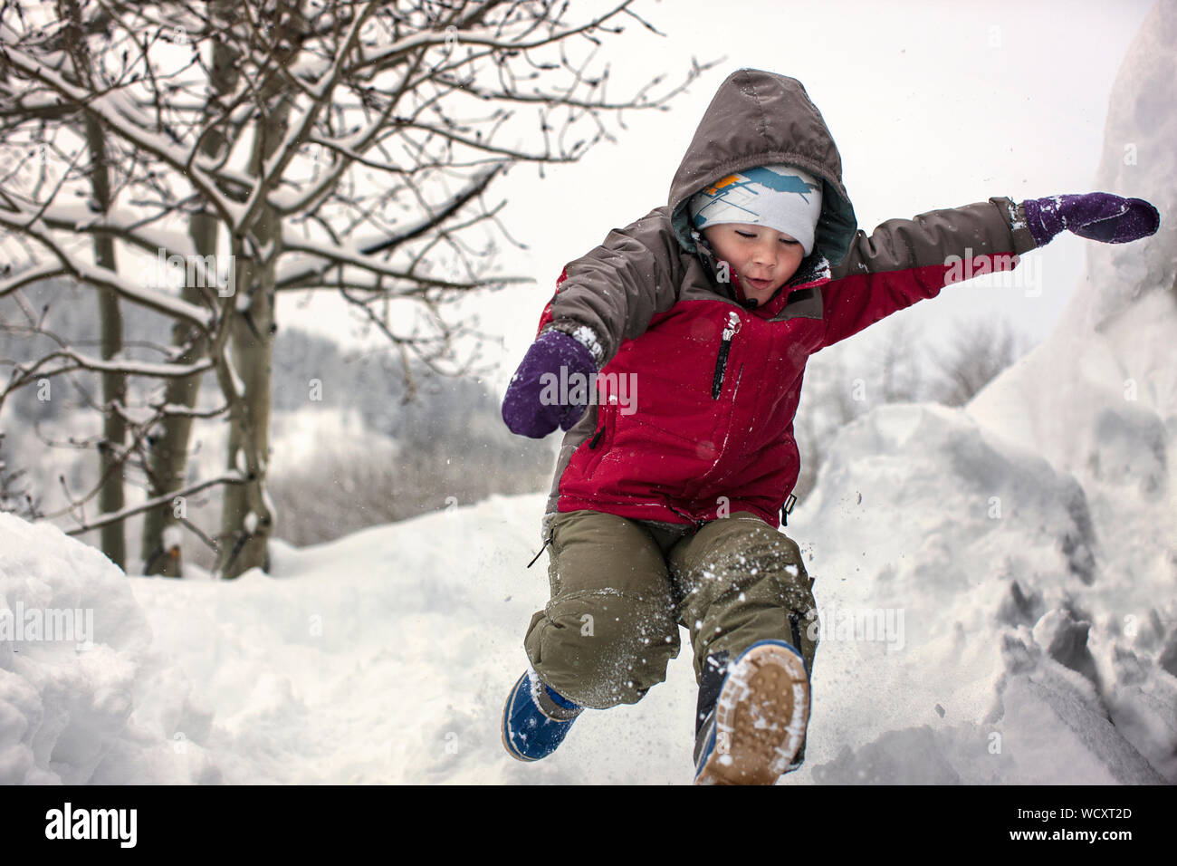 Young boy running through snow Stock Photo - Alamy