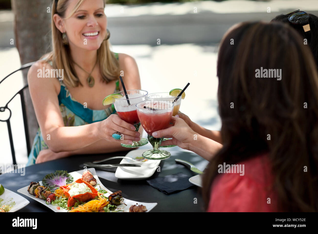 Three smiling friends having lunch at a restaurant Stock Photo - Alamy