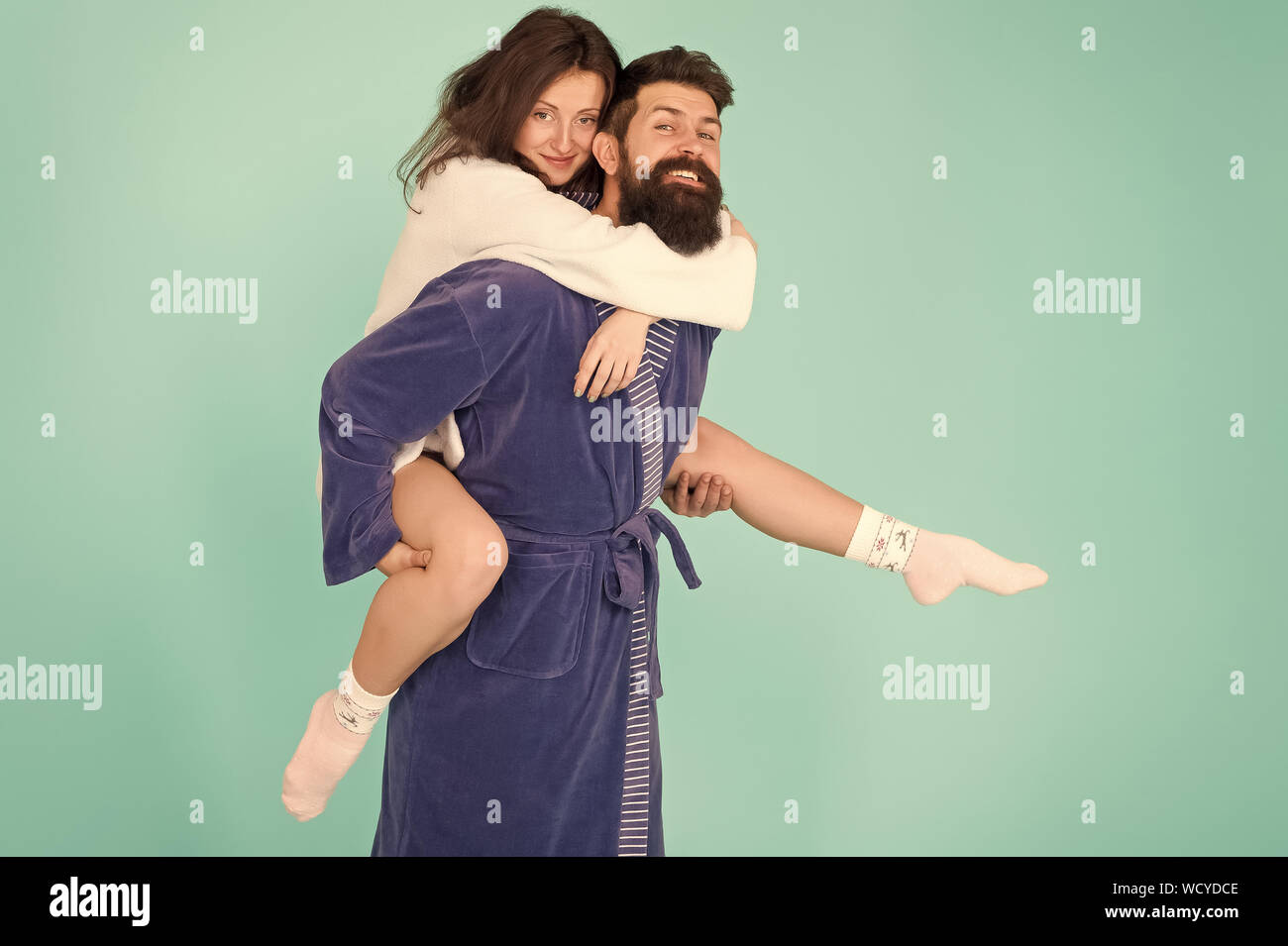Lets stay at home and have fun. Couple in bathrobes having fun ...