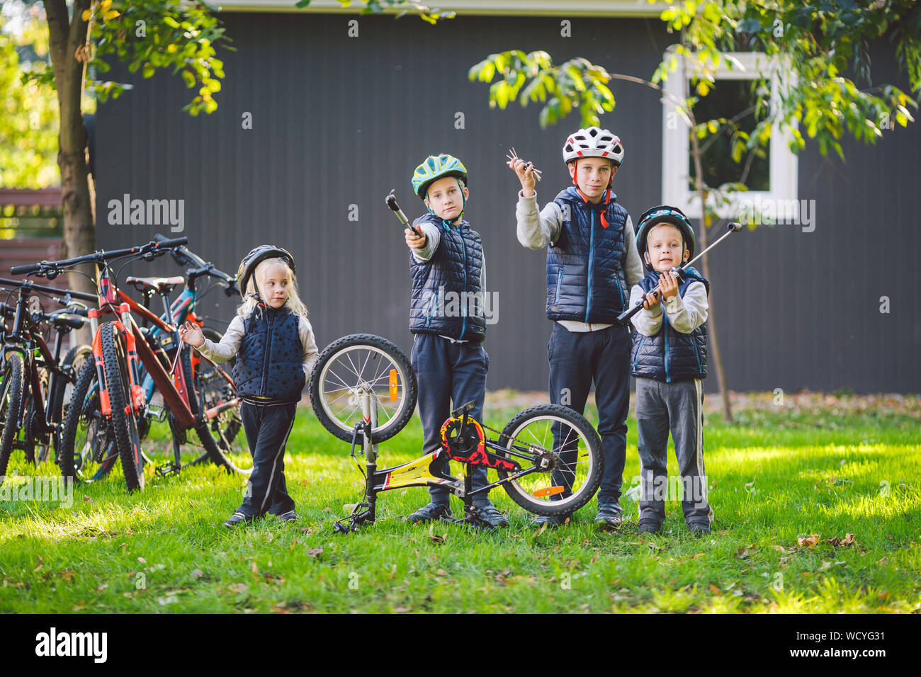 Children mechanics, bicycle repair. Happy kids fixing bike together ...