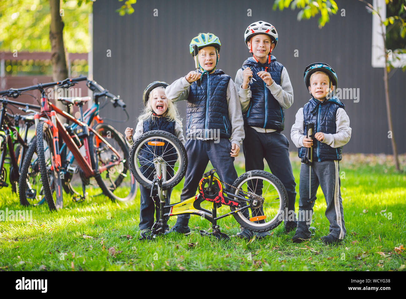 Children mechanics, bicycle repair. Happy kids fixing bike together ...
