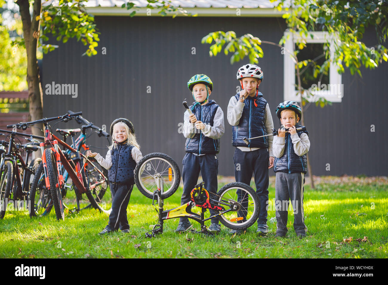 Children mechanics, bicycle repair. Happy kids fixing bike together ...