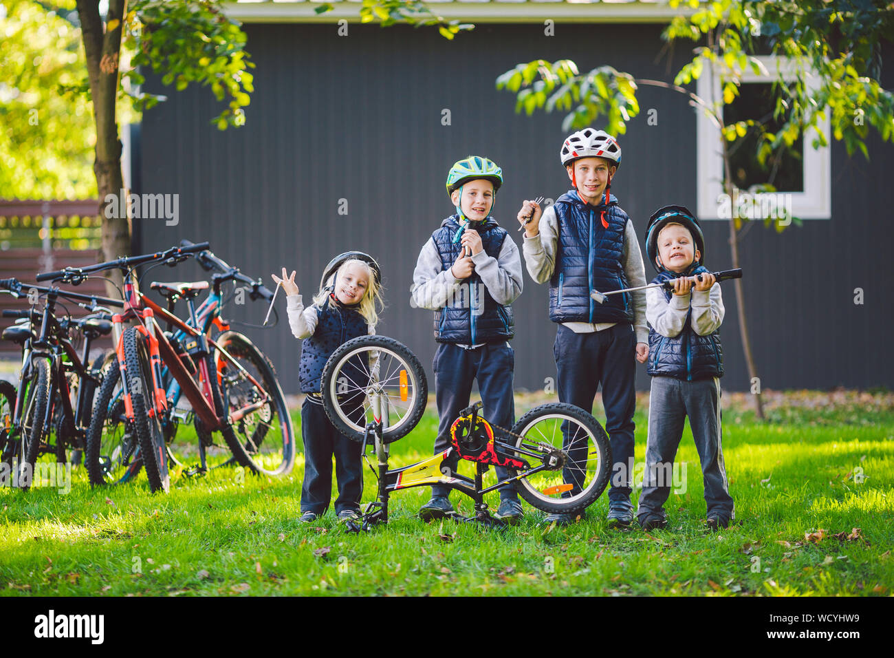 Children mechanics, bicycle repair. Happy kids fixing bike together ...