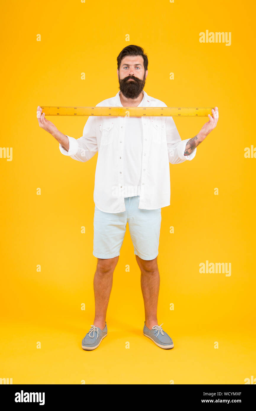 Bearded and moustached. Bearded man measuring beard hair on yellow ...