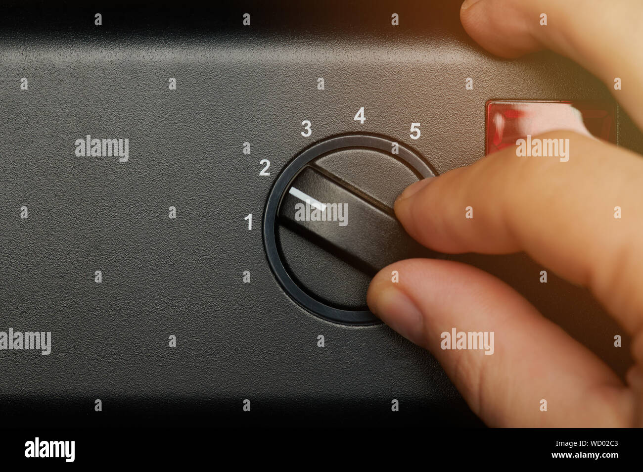 Hand moving round control with numbers on metal background Stock Photo ...