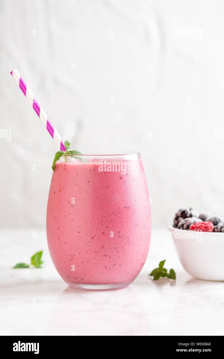 Vertical shot of a delicious mix berry milkshake with different berries ...