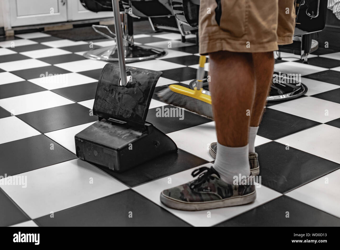 Hairdresser cleans workplace after haircut Stock Photo - Alamy