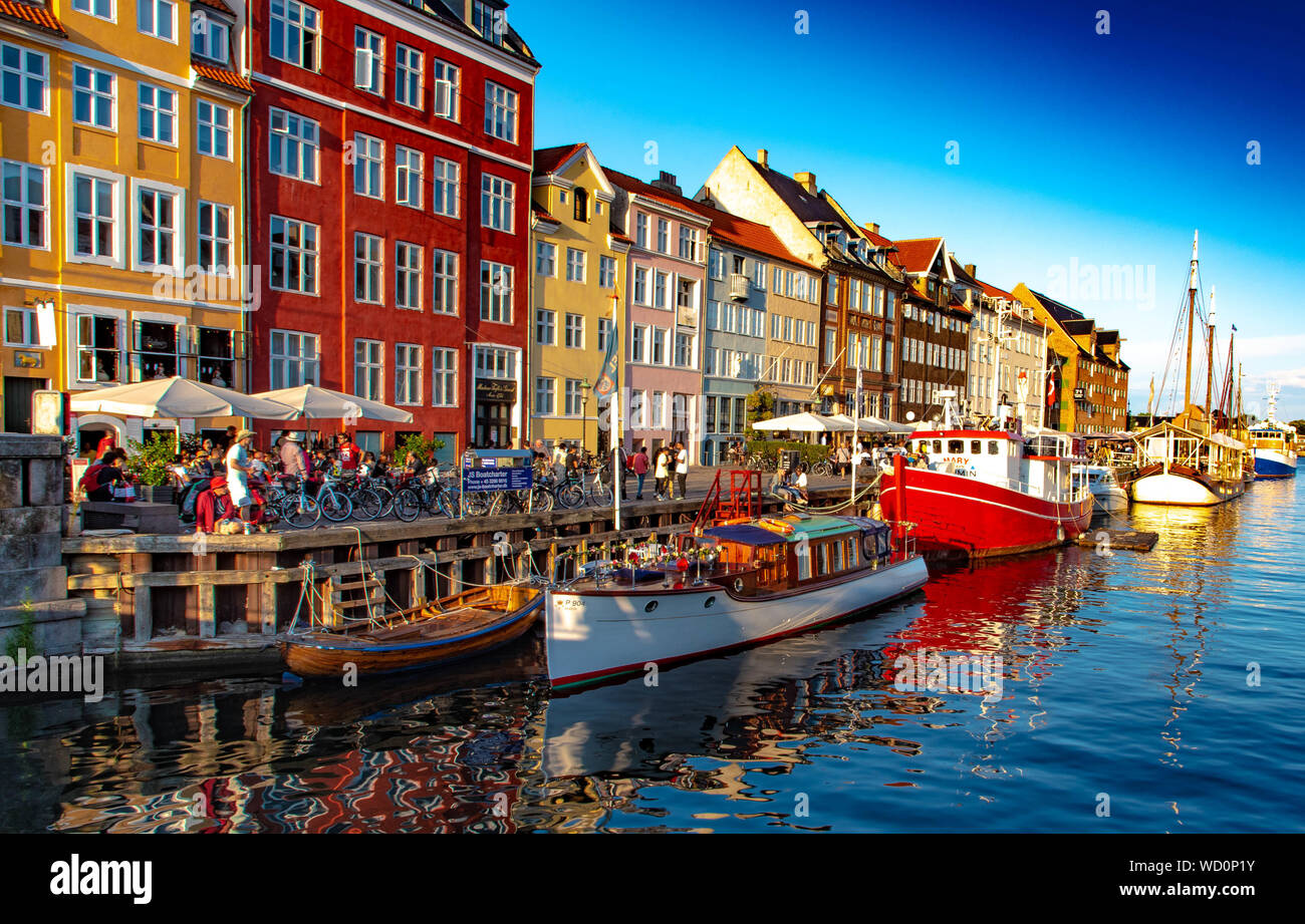 Colorful boats and homes with painter at Nyhavn Canal in Copenhagen ...