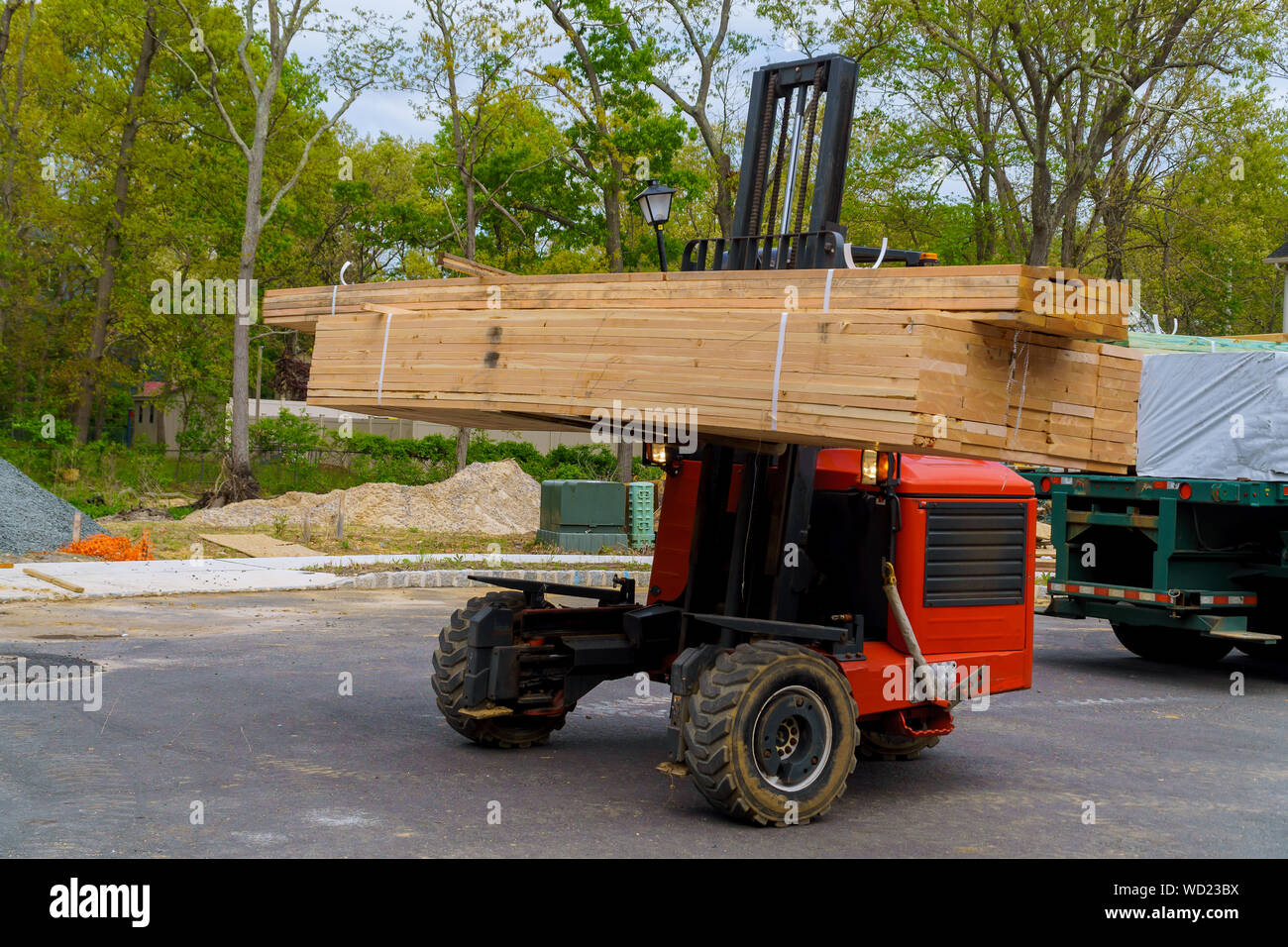 Workers in front of forklift stacker loader palette home framing beams ...