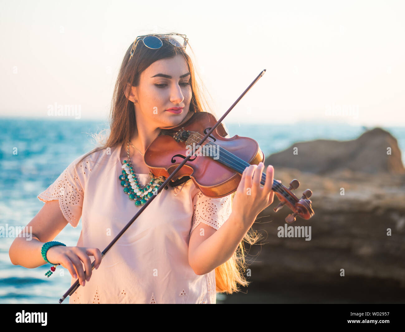 Young Woman Playing Violin While By Sea Stock Photo - Alamy