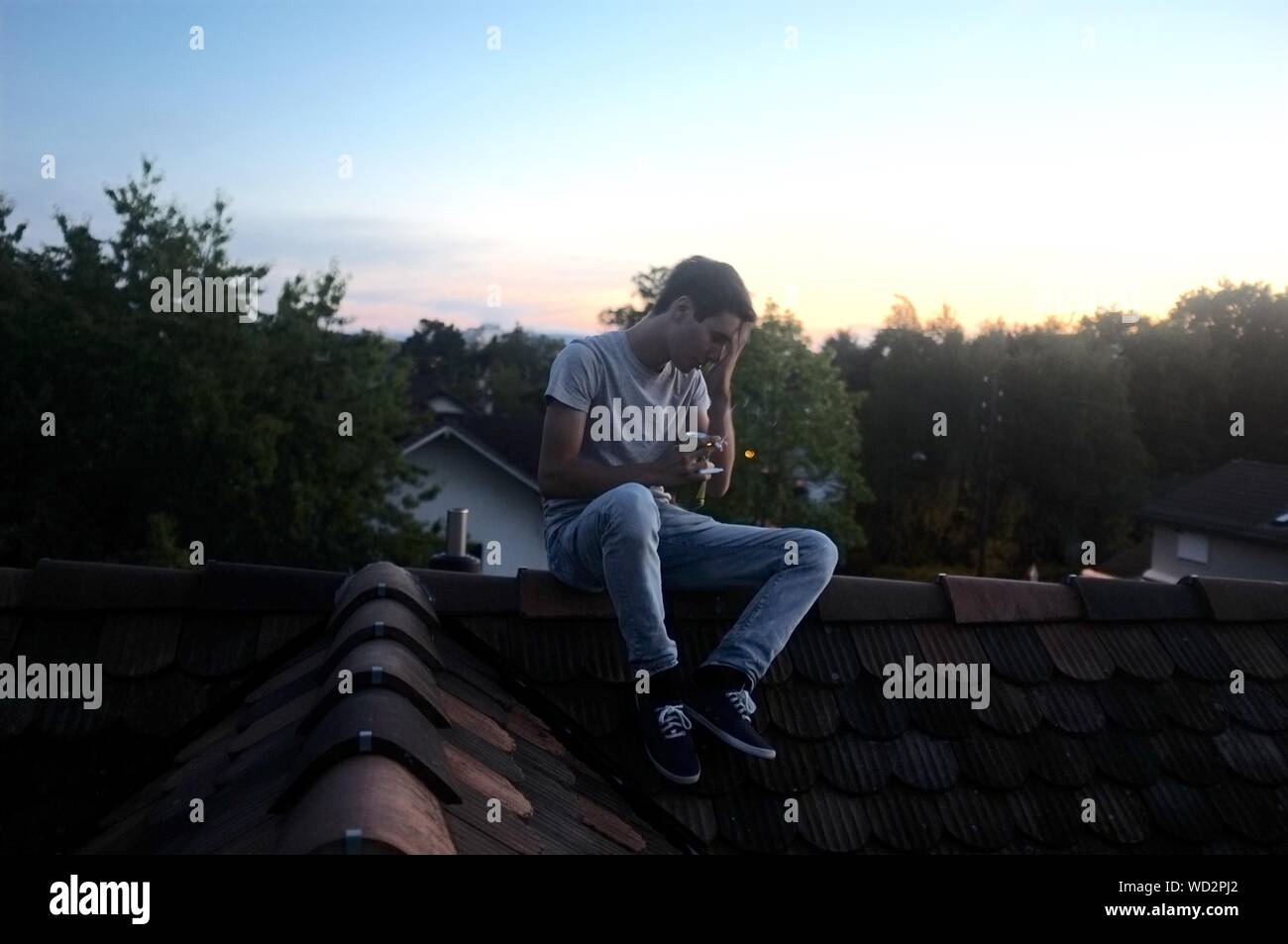 Young man sitting on rooftop hi-res stock photography and images - Alamy