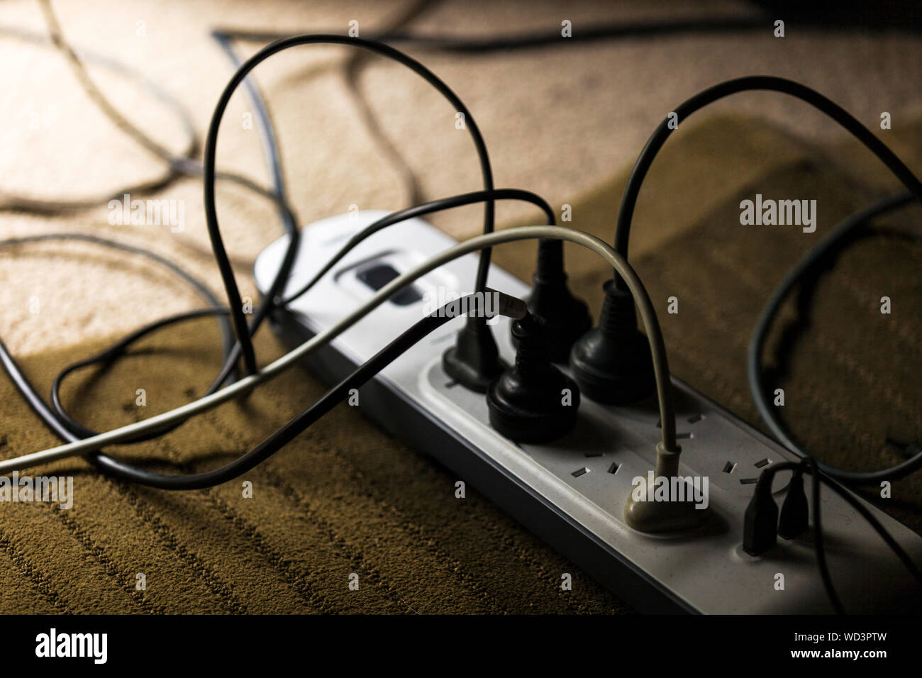 Messy powerboard under remote working desk Stock Photo - Alamy