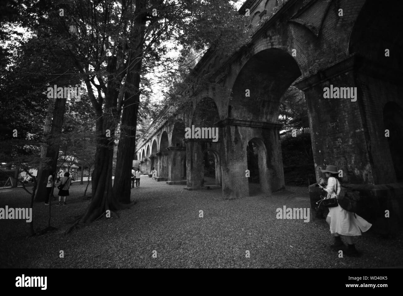 Full Length Of Woman Walking By Arch Buildings Stock Photo - Alamy