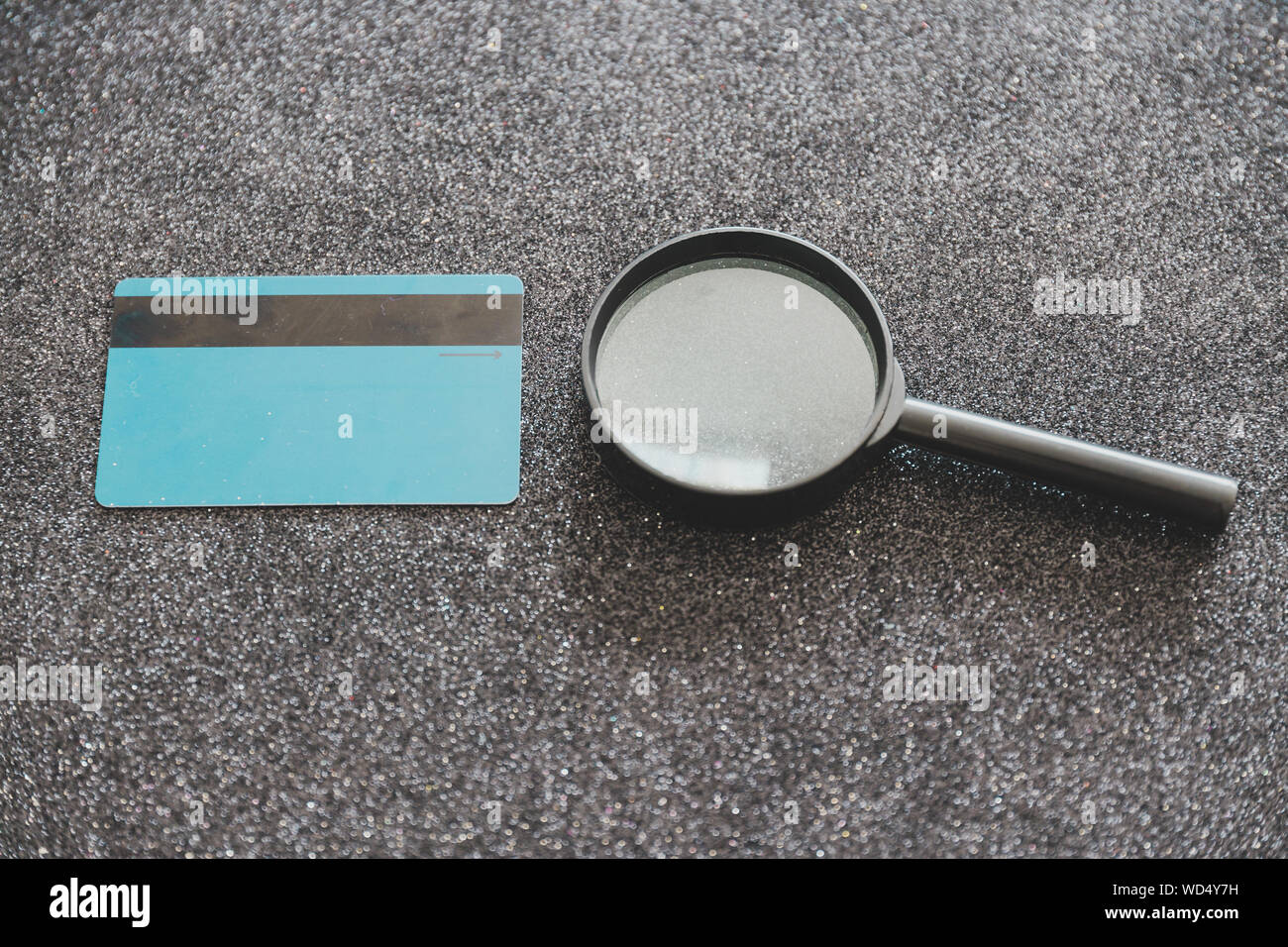 Payment Card And Magnifying Glass Analyzing It On Black Glitter Background Customer Spending
