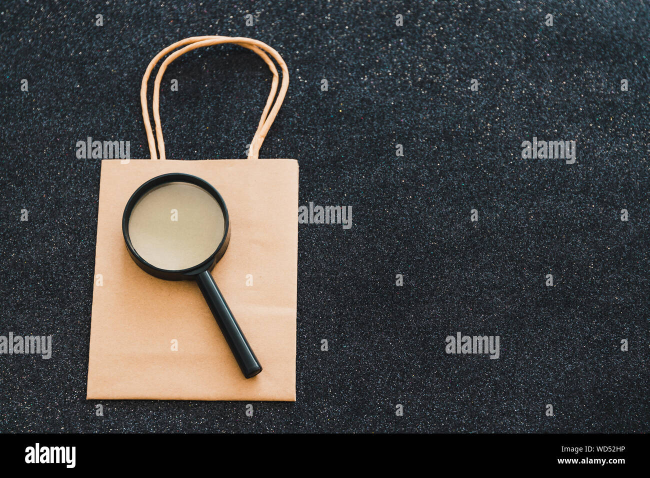 Shopping Bag And Magnifying Glass Analyzing It On Black Glitter Background Customer Spending
