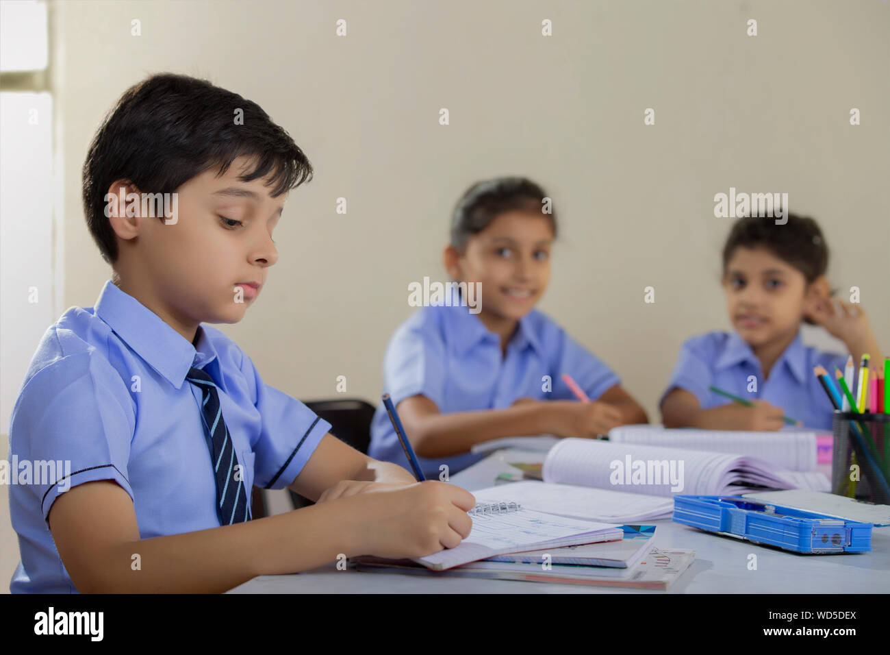 students writing in their notebooks in class Stock Photo - Alamy