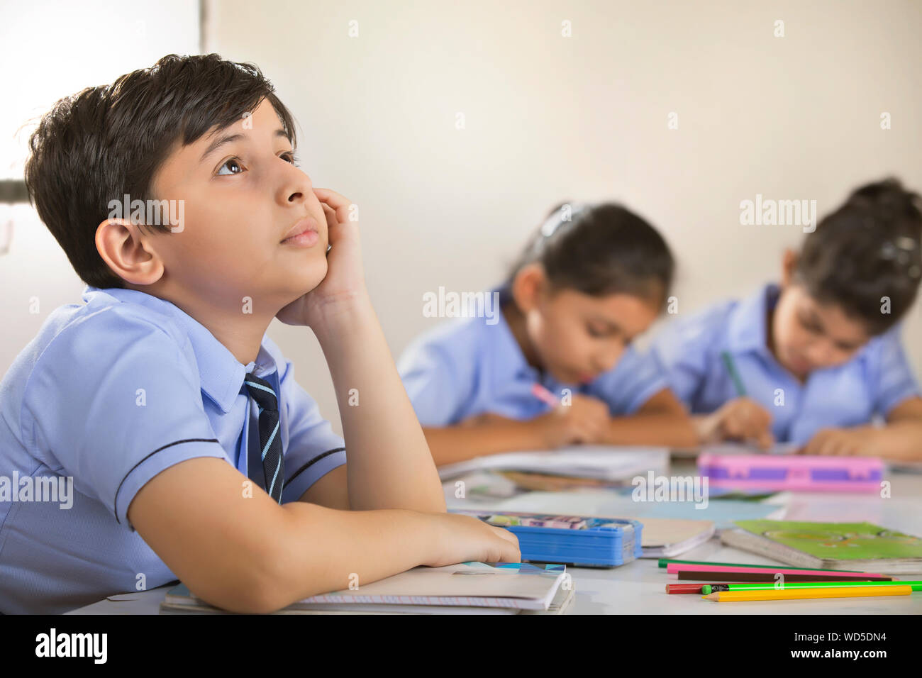 school boy thinking about something in the classroom Stock Photo - Alamy