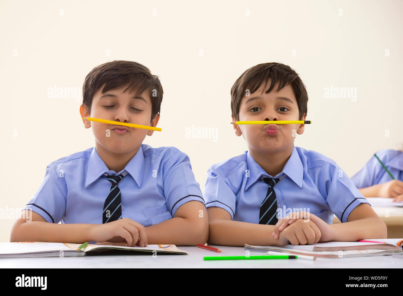 two school boys playing with pencils in class Stock Photo - Alamy