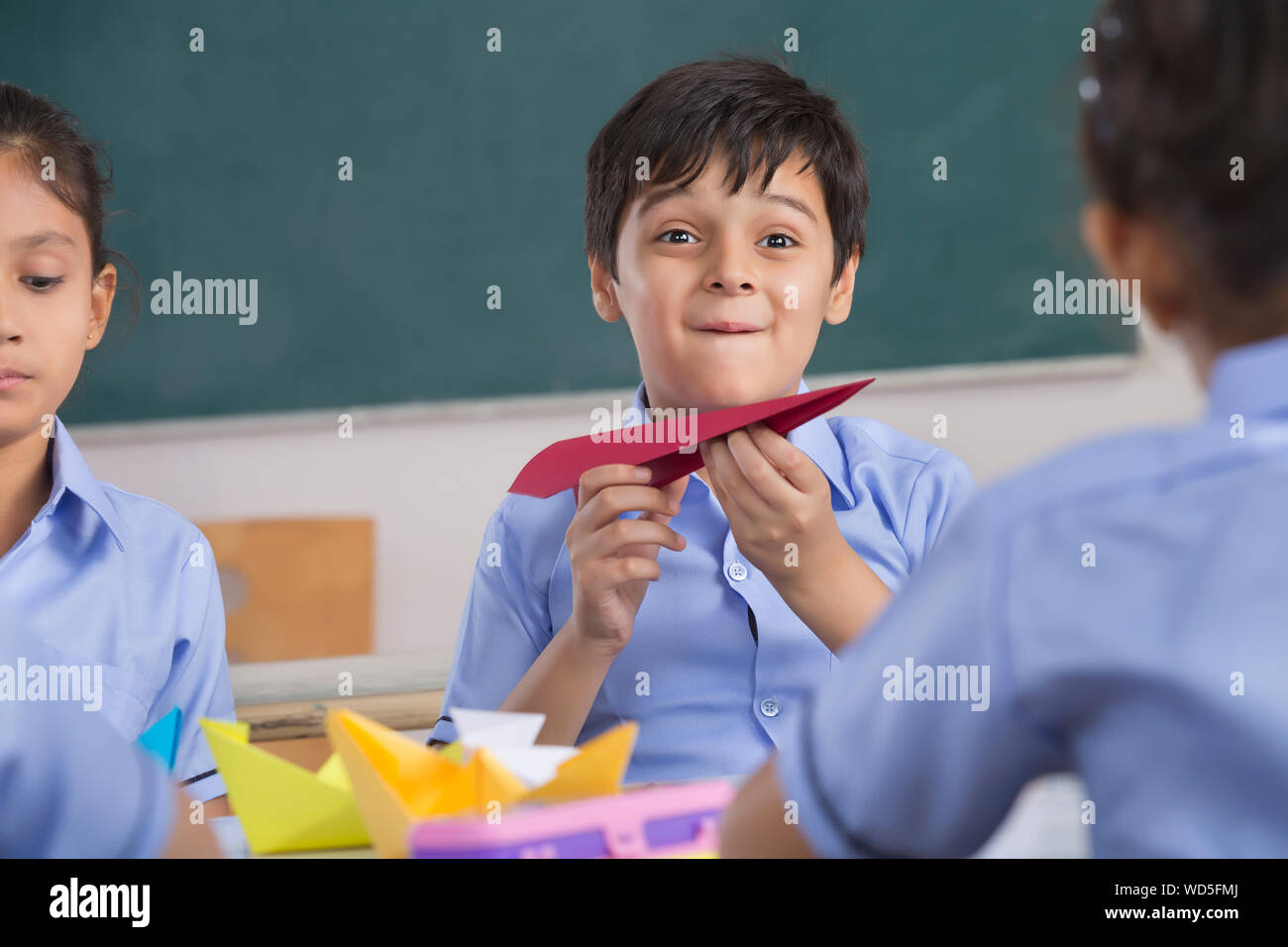 children playing with paper plane and boat in class Stock Photo - Alamy