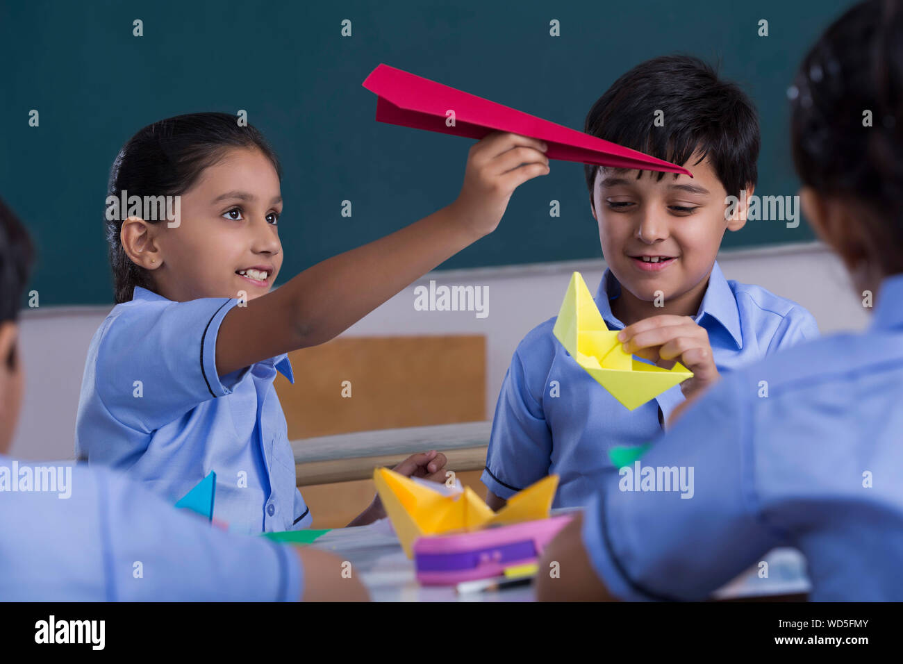 children playing with paper plane and boat in class Stock Photo - Alamy