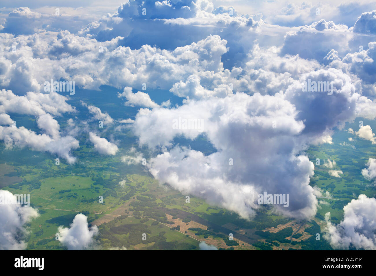 Green grass fields, forests, blue sky and white cumulus fluffy clouds ...