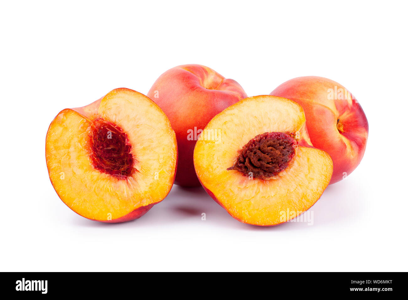 Peaches whole and halves with a stone inside on a white background ...